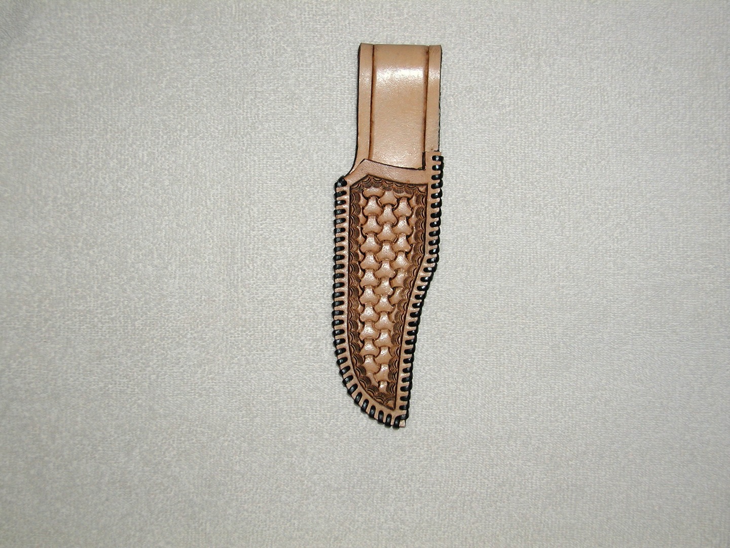 Hunting knife sheath with geometric stamp and whip laced